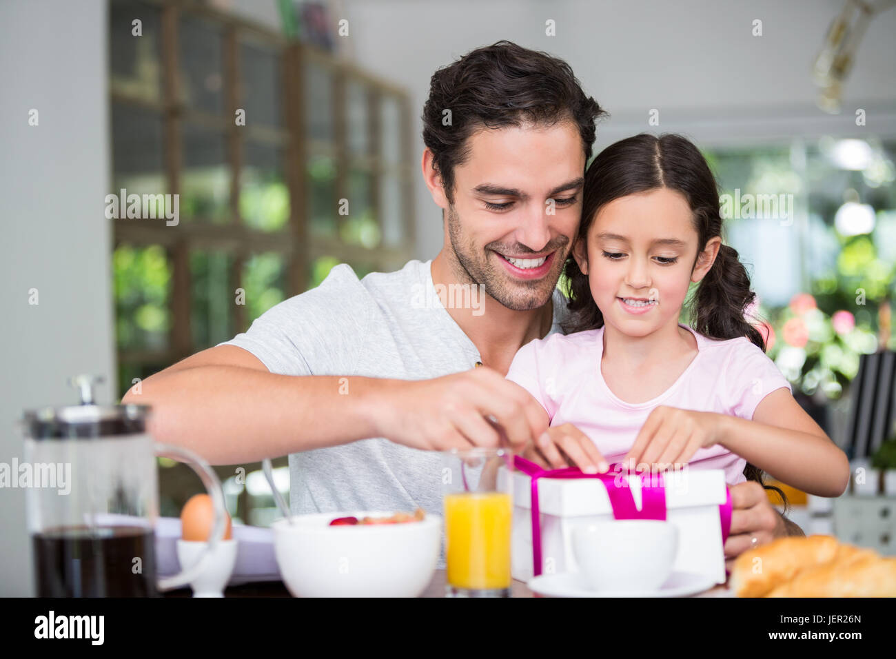 Smiling father and daughter opening gift box Stock Photo - Alamy