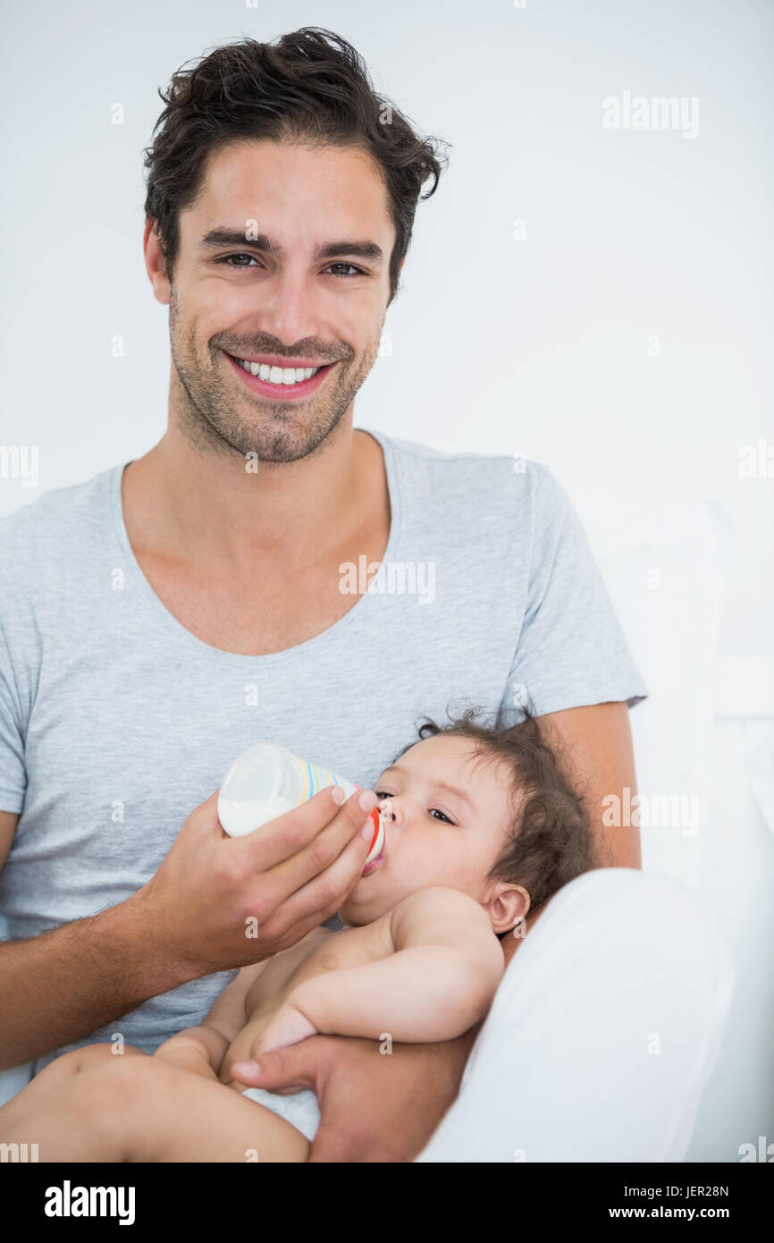 Man feeding milk to baby girl Stock Photo - Alamy