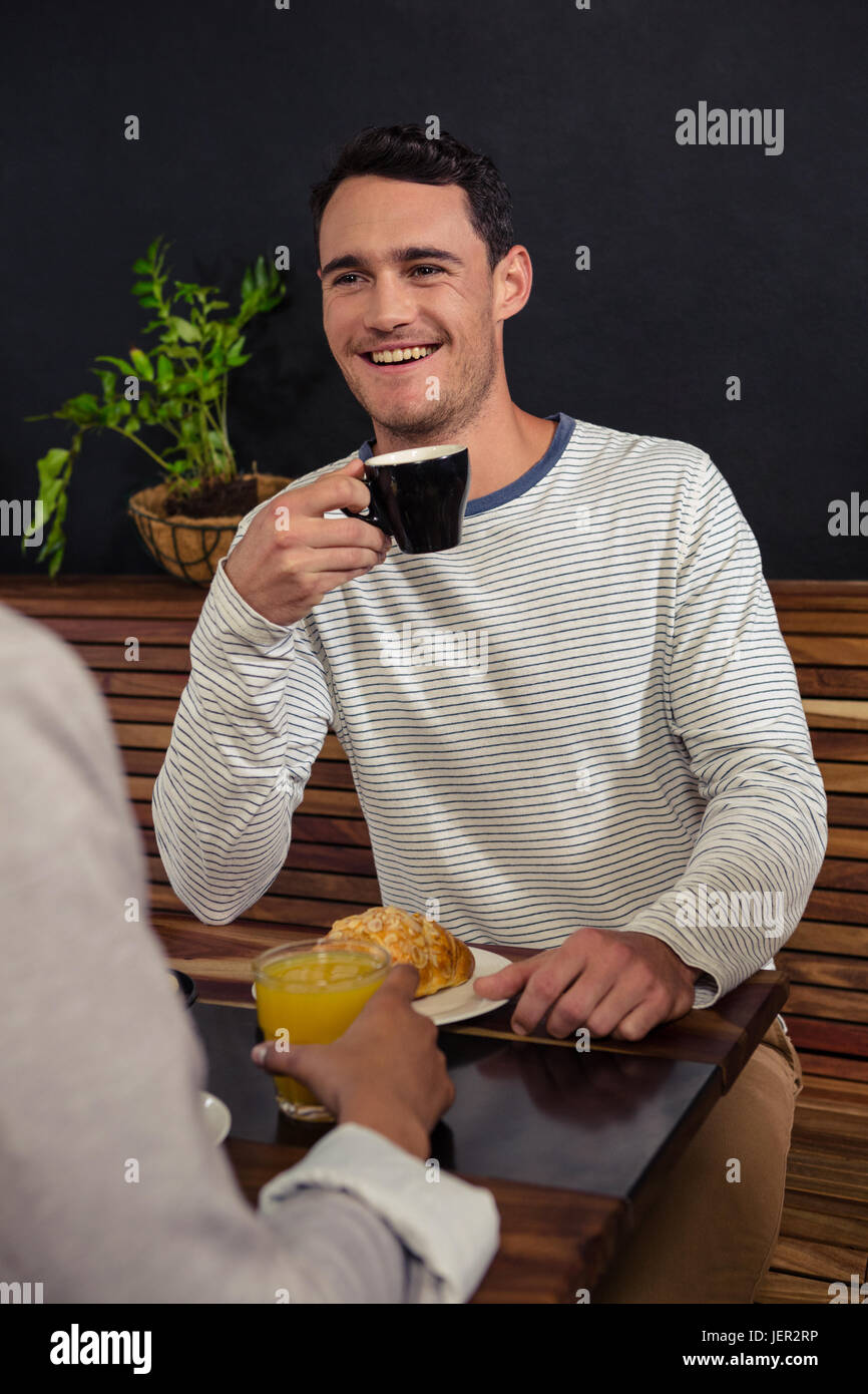 Cute couple talking while eating Stock Photo - Alamy