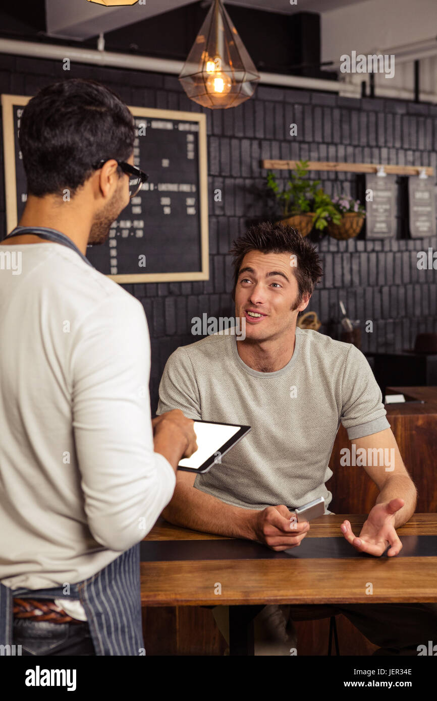 Waiter and customer talking Stock Photo - Alamy