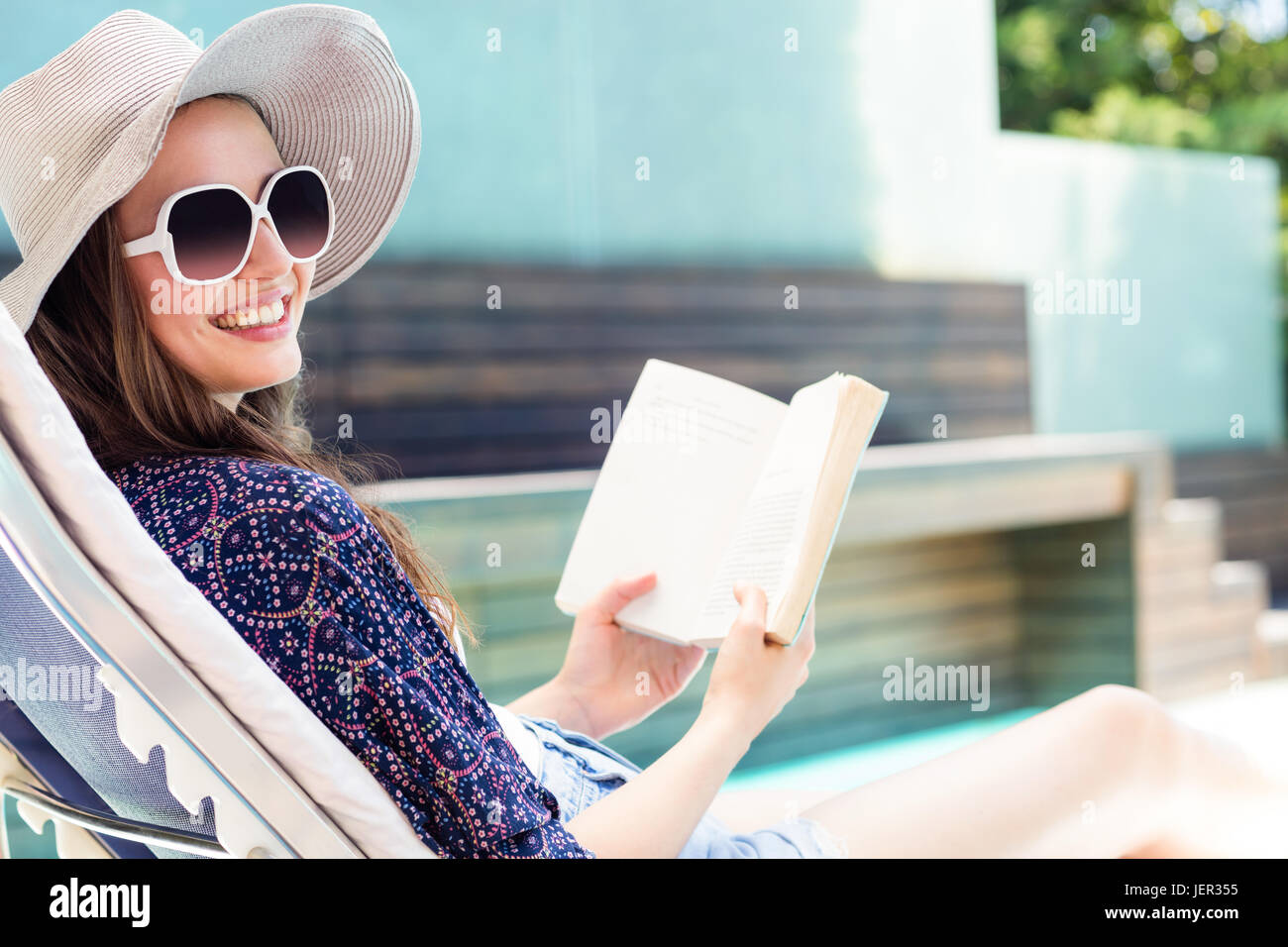 Woman relaxing pool reading book hi-res stock photography and images ...