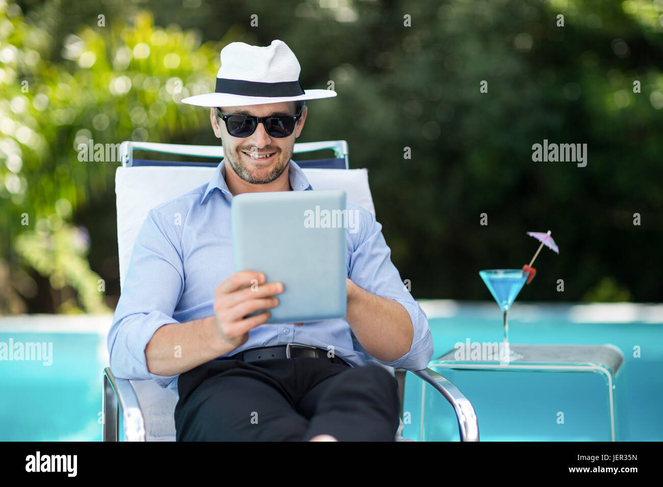Smart man using digital tablet near pool Stock Photo - Alamy