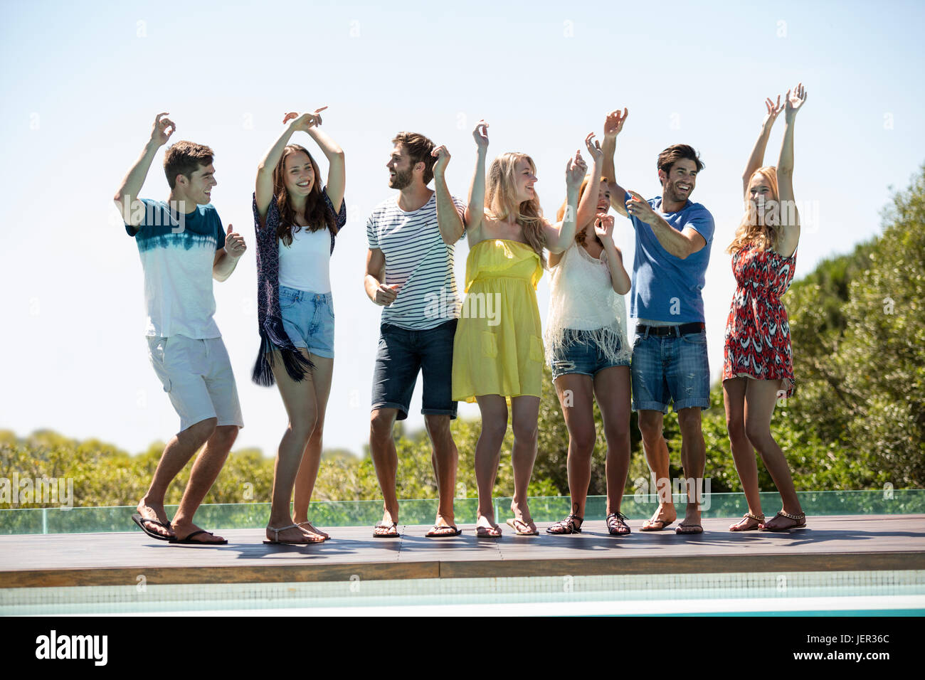 Happy friends dancing near the swimming pool Stock Photo - Alamy