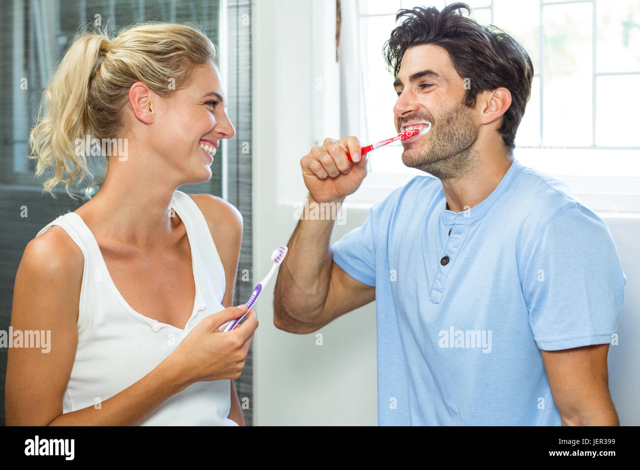 Couple brushing their teeth in bathroom Stock Photo - Alamy