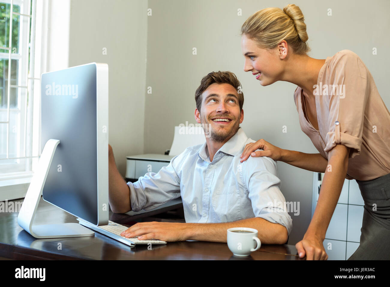 Happy colleagues discussing at office Stock Photo - Alamy