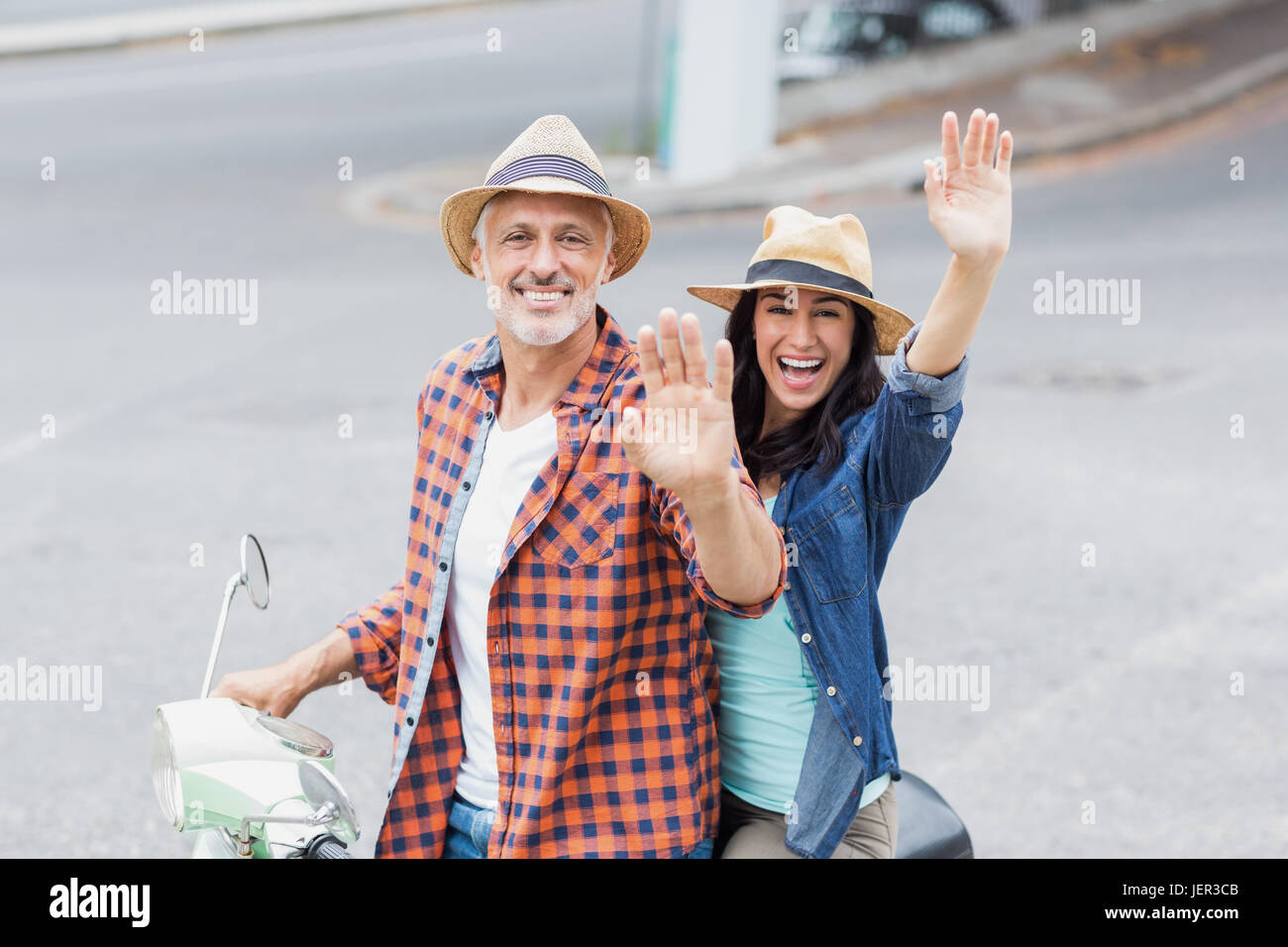 Portrait of cheerful couple waving hands Stock Photo - Alamy