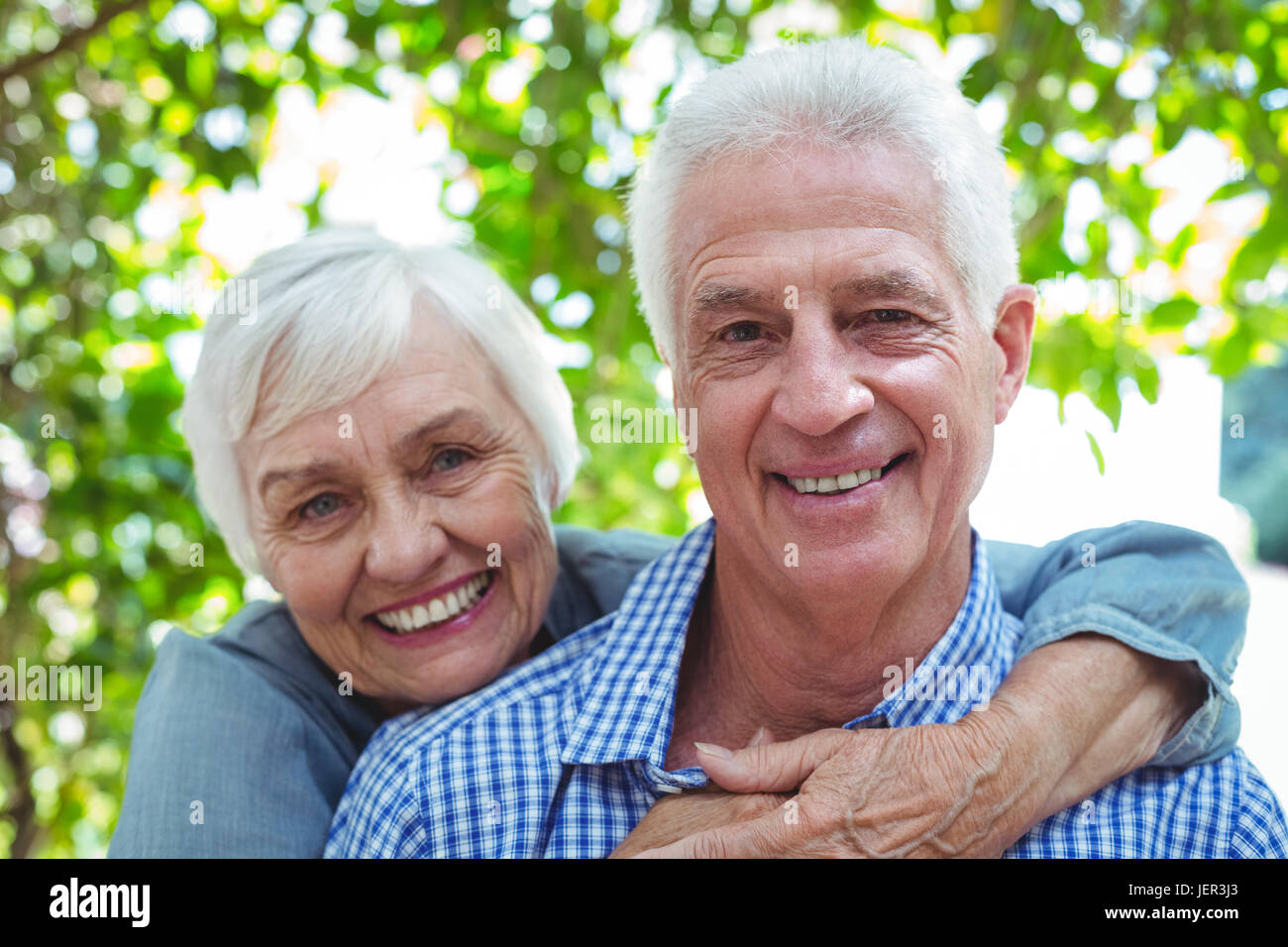 Confident retired couple embracing Stock Photo - Alamy