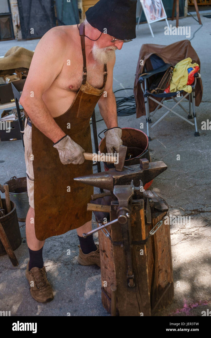Blacksmith creating objects from wrought iron by forging the metal ...