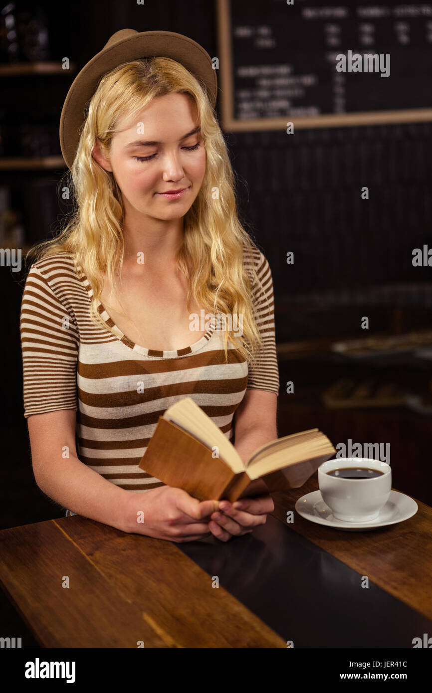 Woman drinking coffee and reading book Stock Photo - Alamy