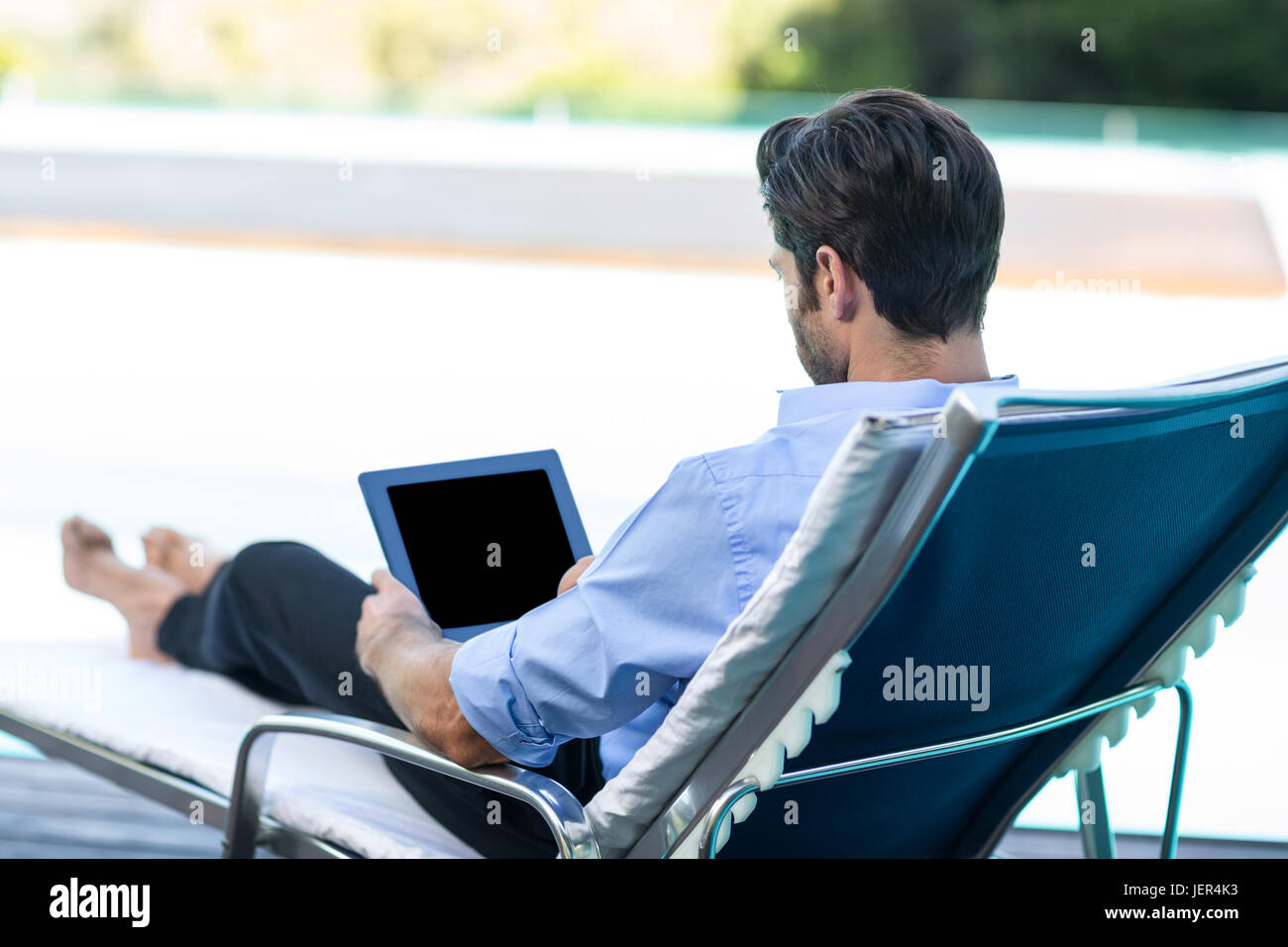 Man using digital tablet near pool Stock Photo - Alamy