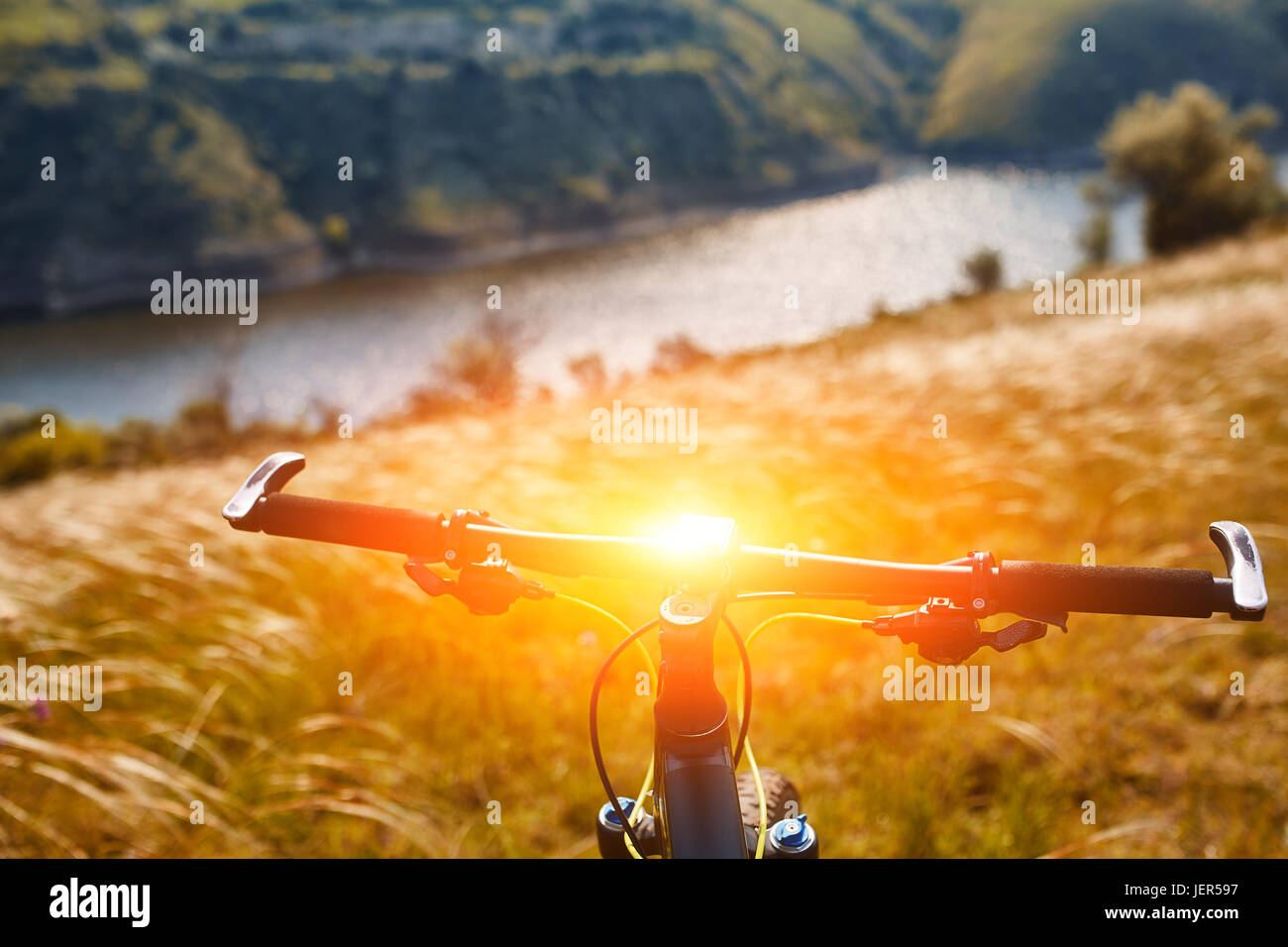 Mountain biking down hill descending fast on bicycle. View from bikers ...