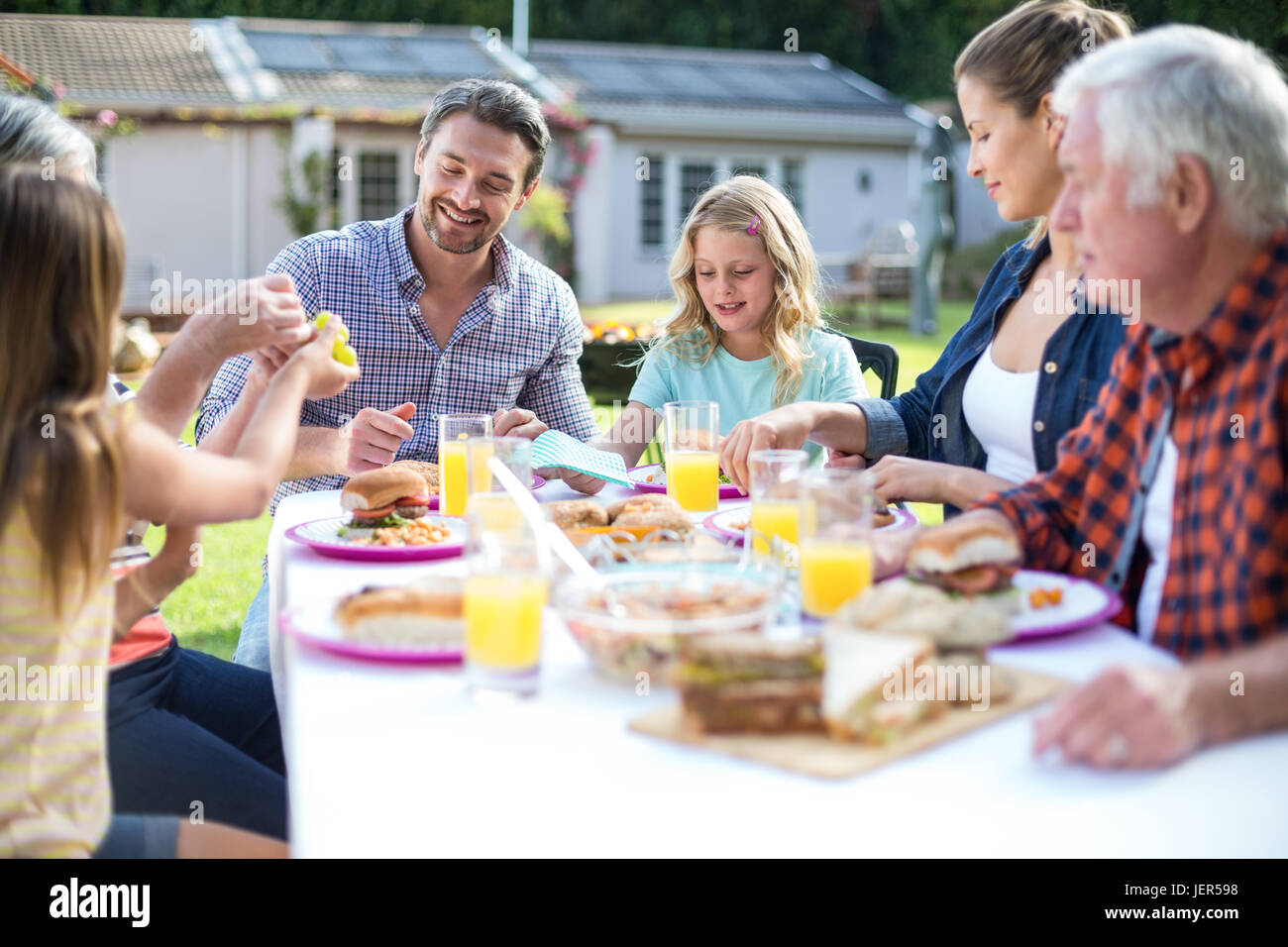 Happy multi-generation family eating at table Stock Photo - Alamy