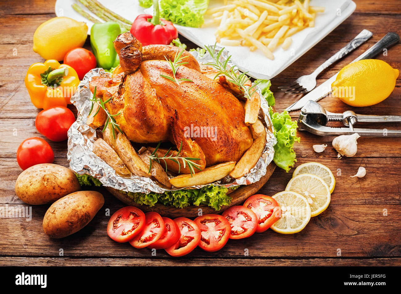 Whole roasted chicken with vegetables on wood table Stock Photo - Alamy