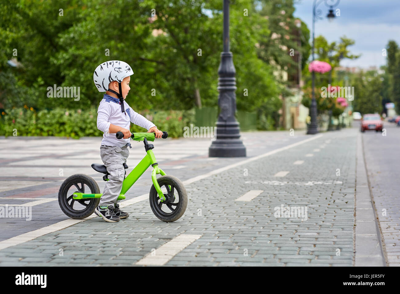 Child boy in white helmet riding on his first bike with a helmet. Bike ...