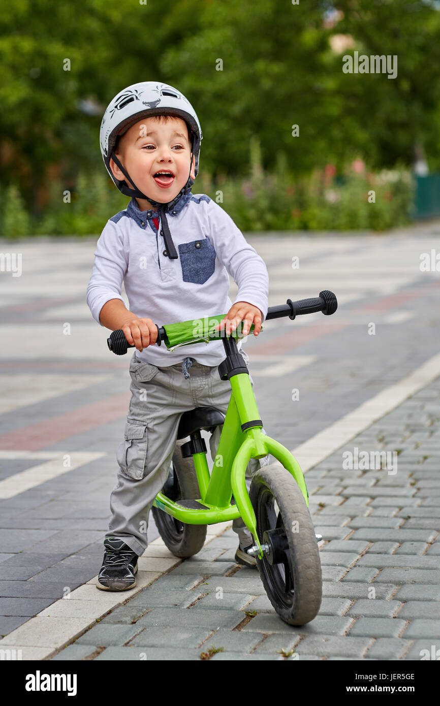 Child boy in white helmet riding on his first bike with a helmet. Bike ...