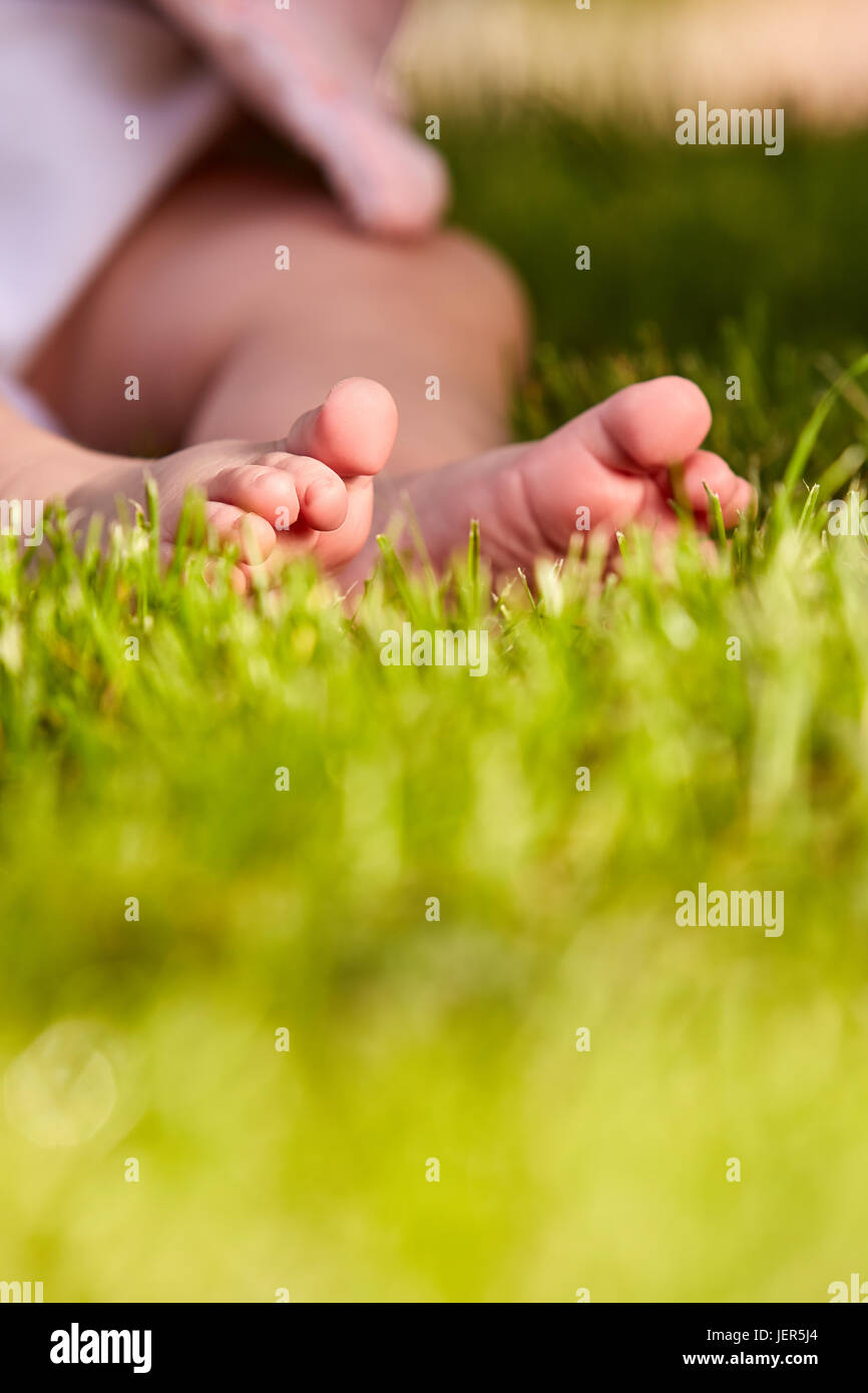 Baby feet in the green grass at summer warm day in the city park Stock ...