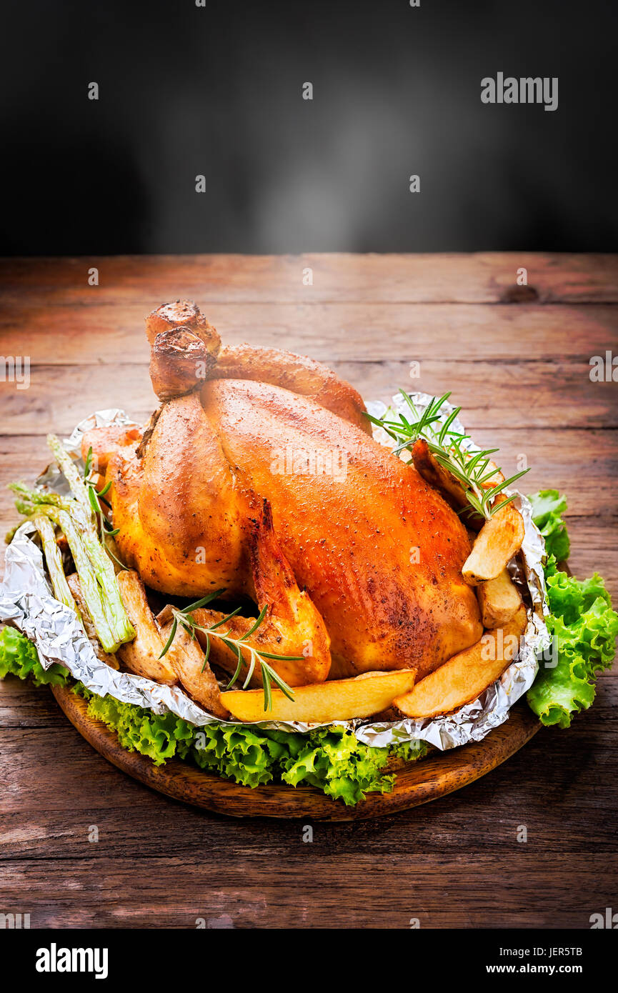 Whole roasted chicken on table background Stock Photo - Alamy