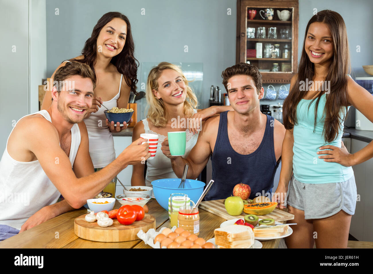 Happy young friends having breakfast at home Stock Photo - Alamy
