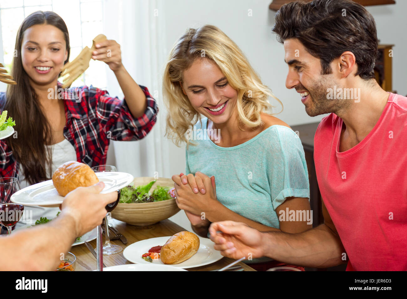 Happy friends smiling while having lunch Stock Photo - Alamy