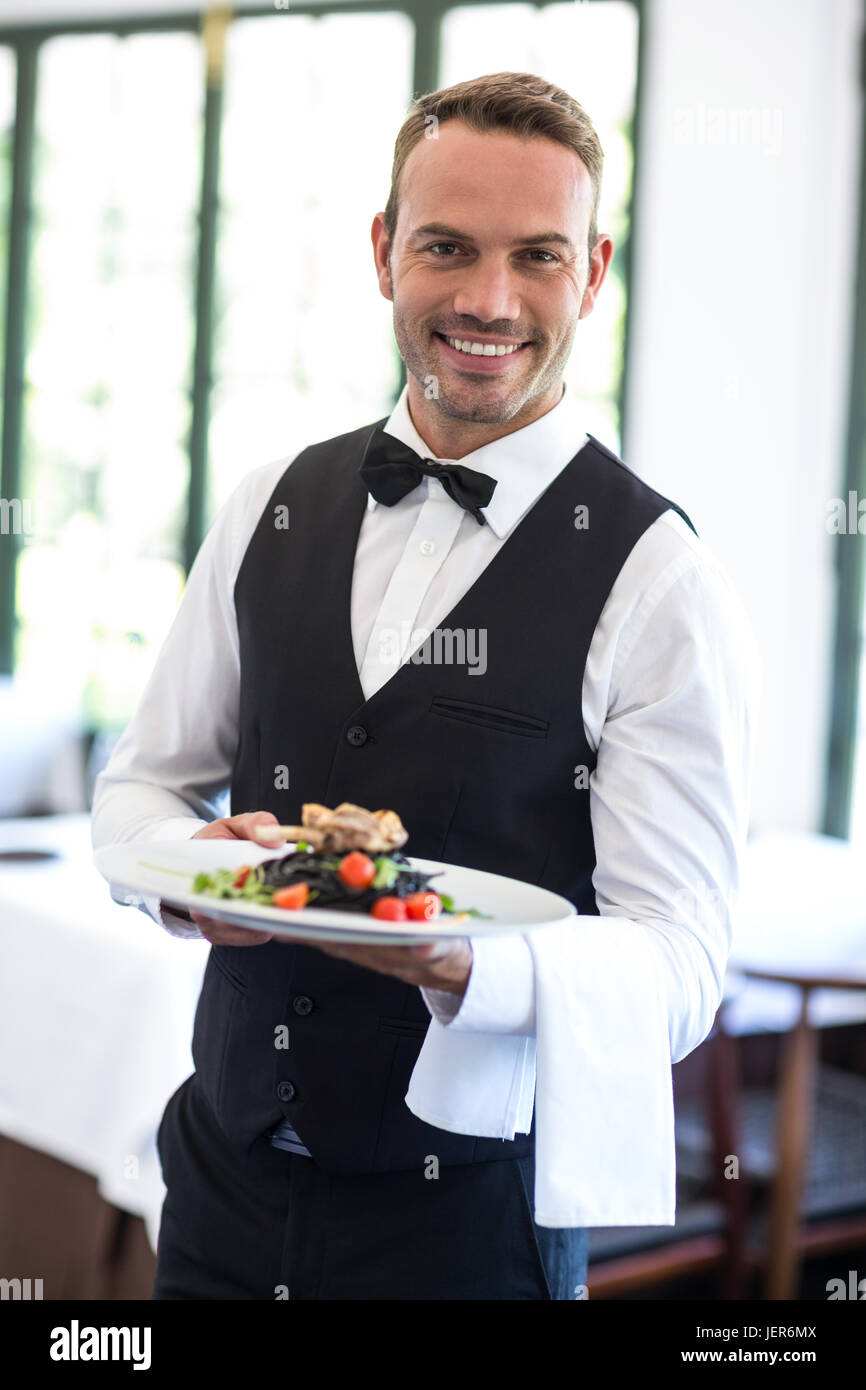 Waiter showing a dish Stock Photo - Alamy