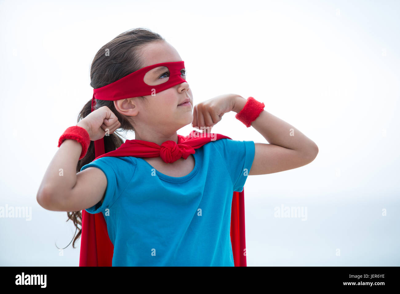 Girl in superhero costume flexing muscles Stock Photo - Alamy