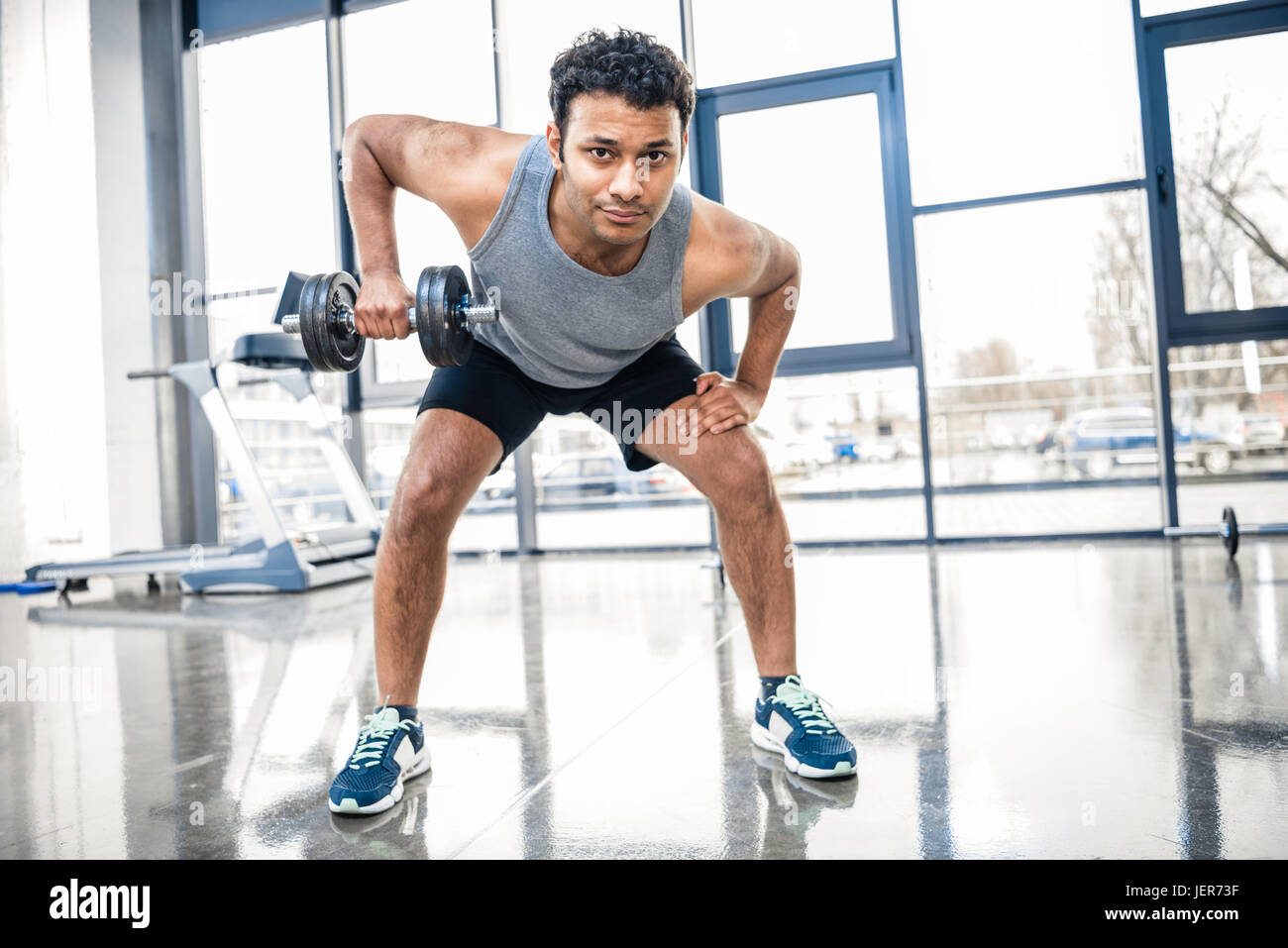 Handsome young man workout with dumbbell at gym Stock Photo - Alamy