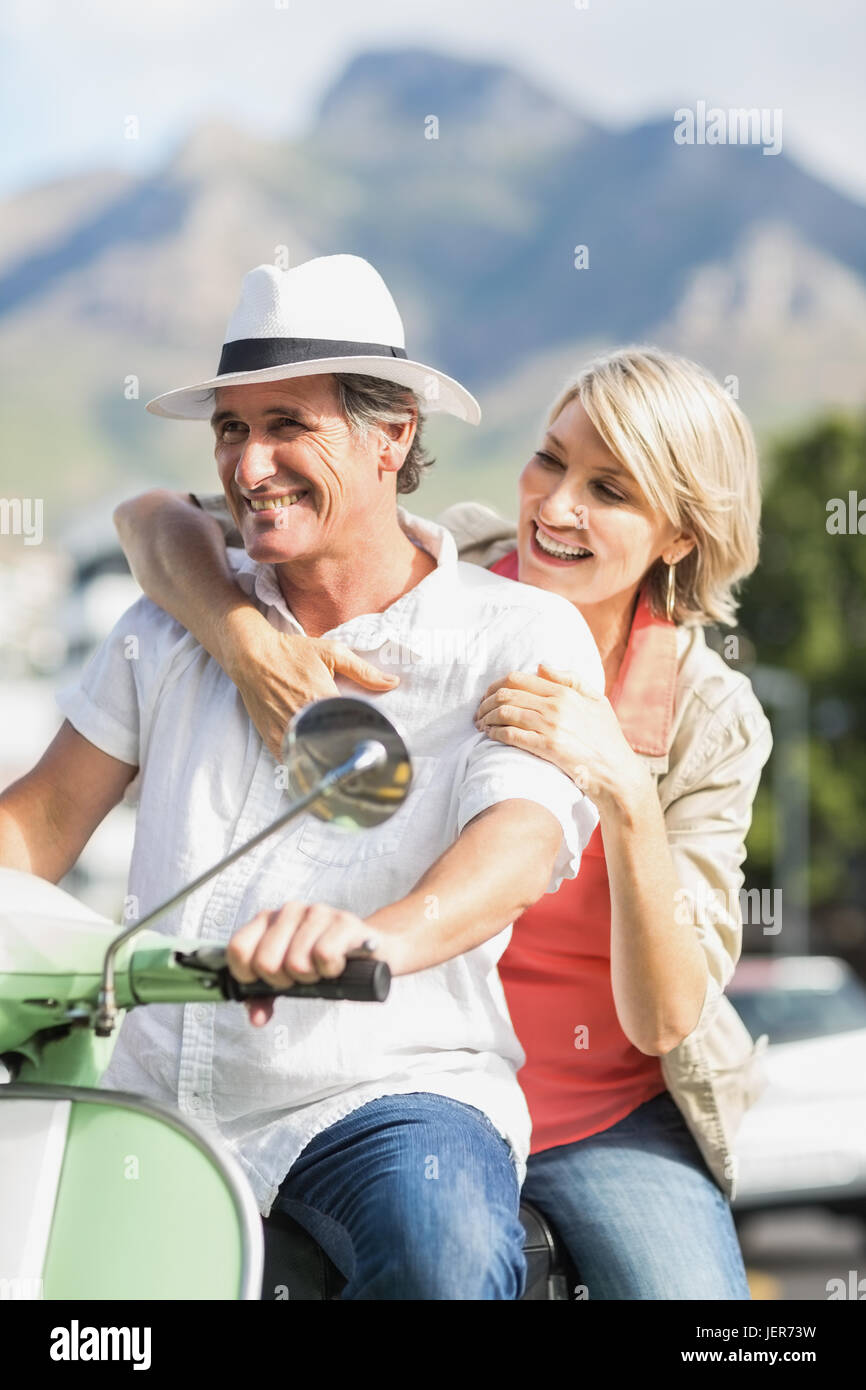 Couple riding motor scooter Stock Photo - Alamy