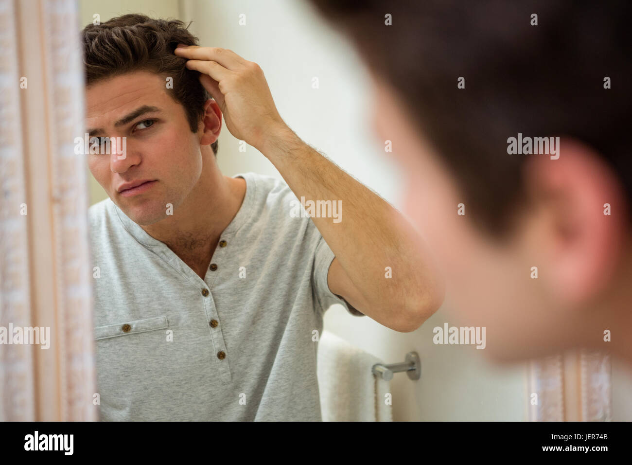 Man checking his hair in mirror Stock Photo - Alamy