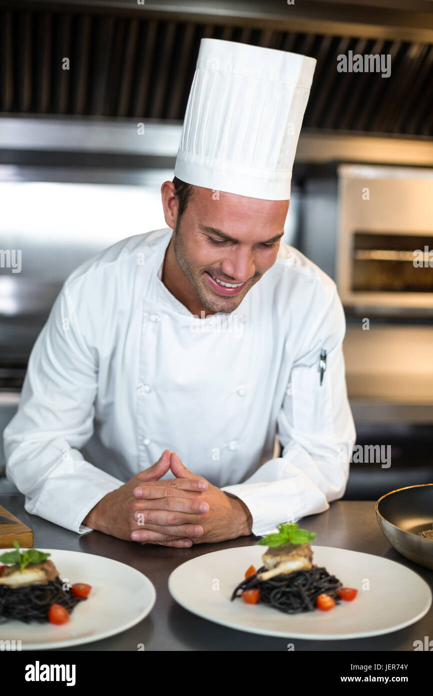 Handsome chef looking at meal Stock Photo - Alamy