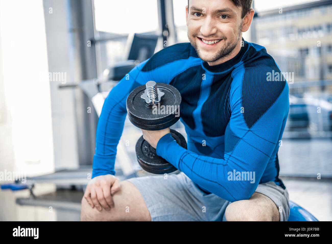 Handsome young man workout with dumbbell at gym Stock Photo - Alamy