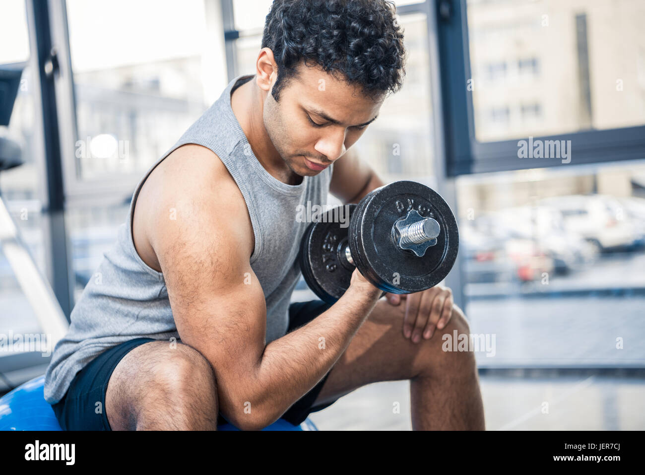 Handsome young man workout with dumbbell at gym Stock Photo - Alamy