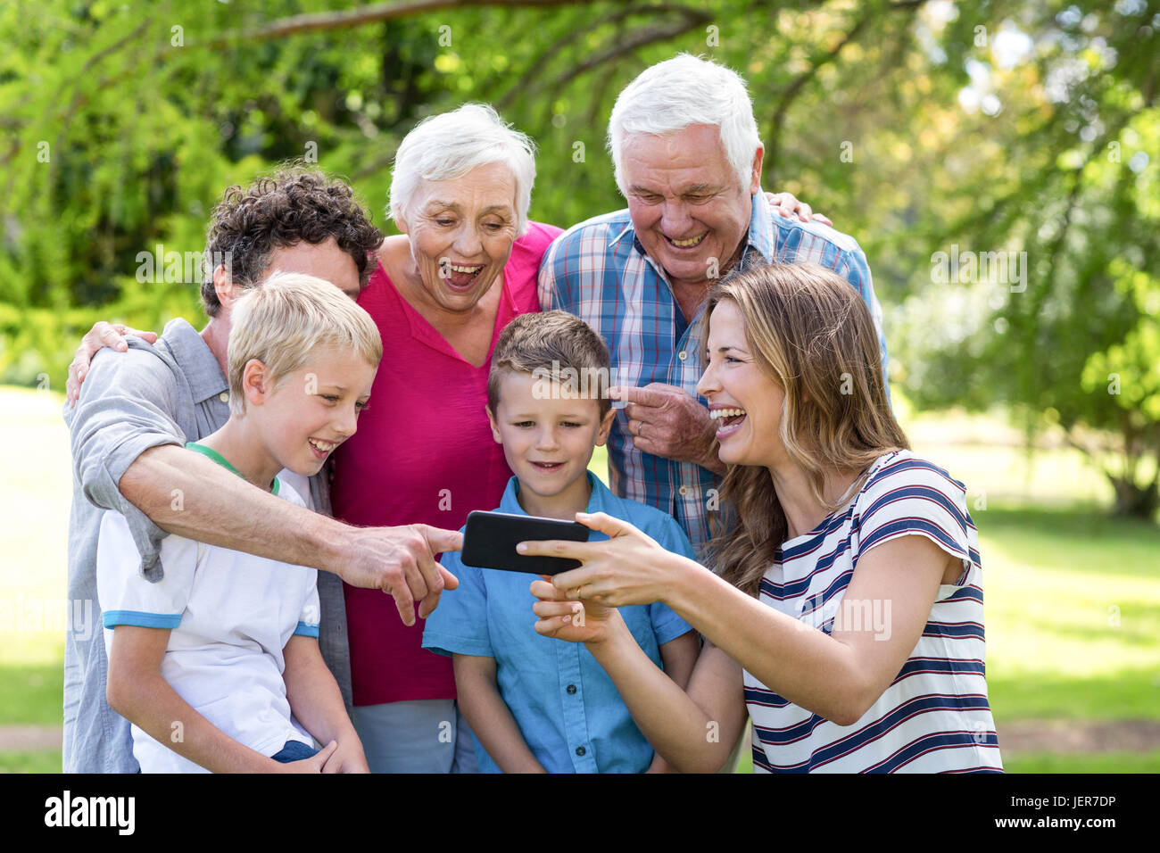Smiling family using smartphone Stock Photo - Alamy
