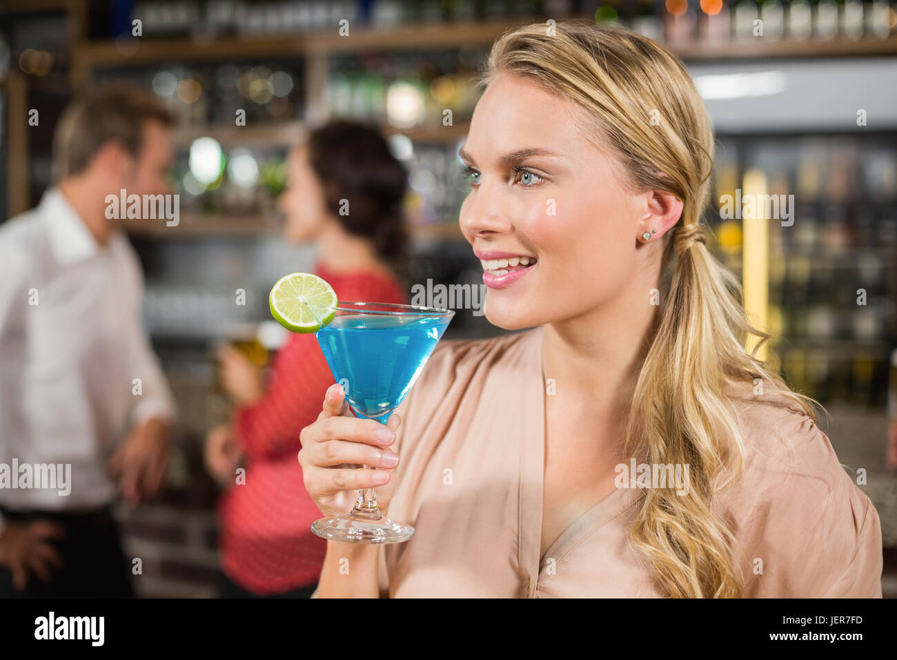 Attractive woman holding cocktail glass Stock Photo - Alamy