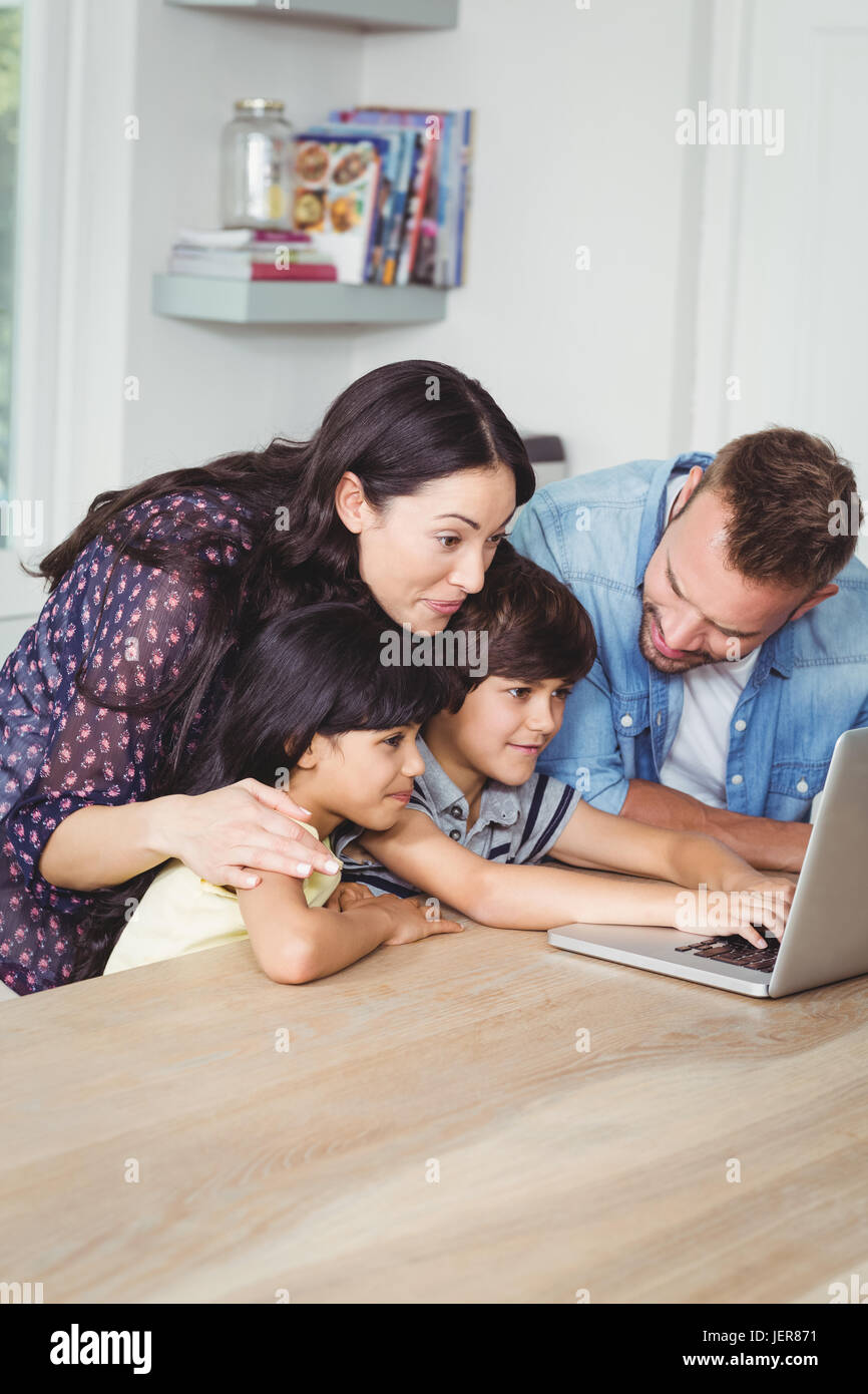 Smiling family using laptop together Stock Photo - Alamy