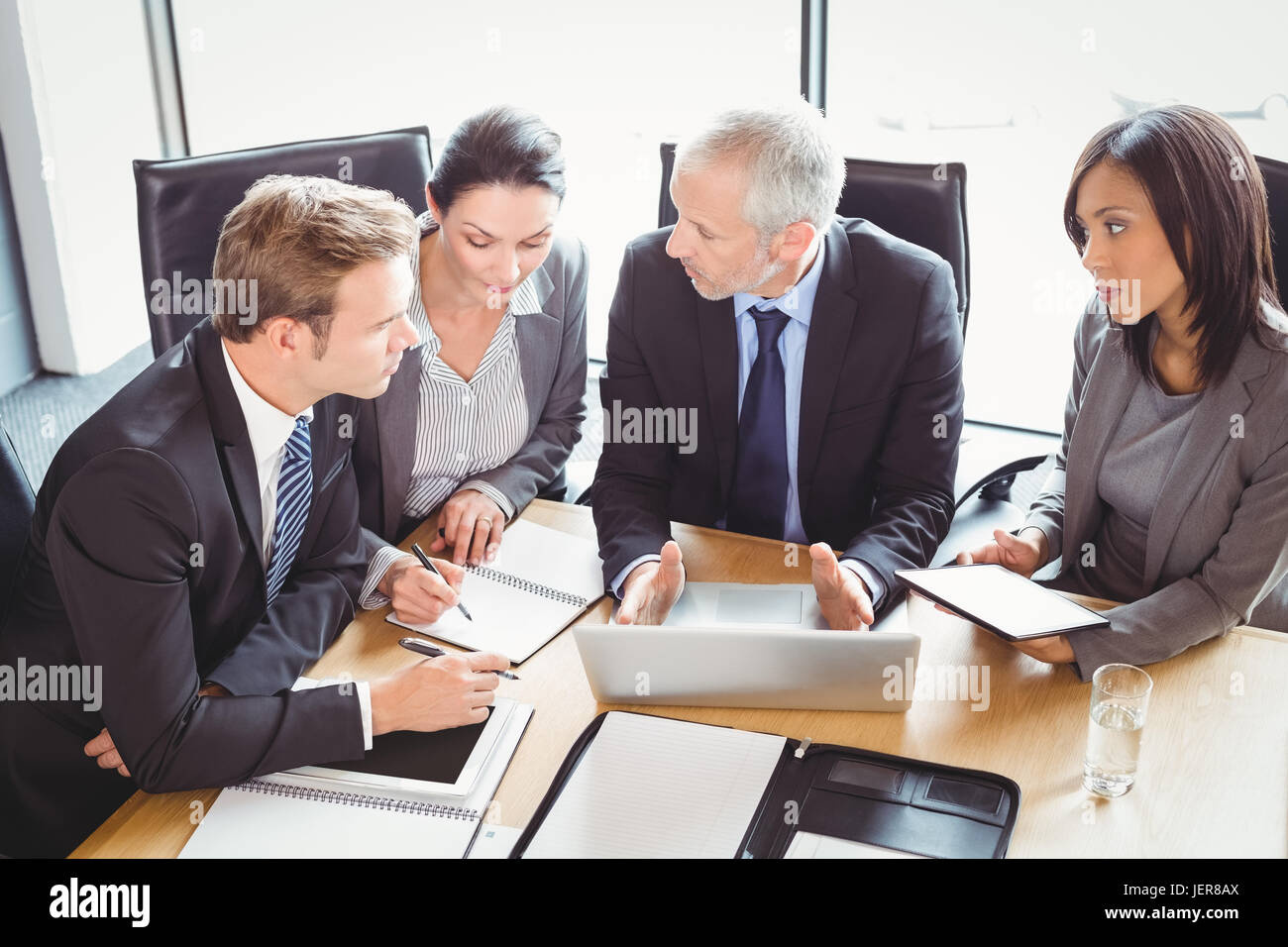 Businesspeople interacting in conference room Stock Photo - Alamy