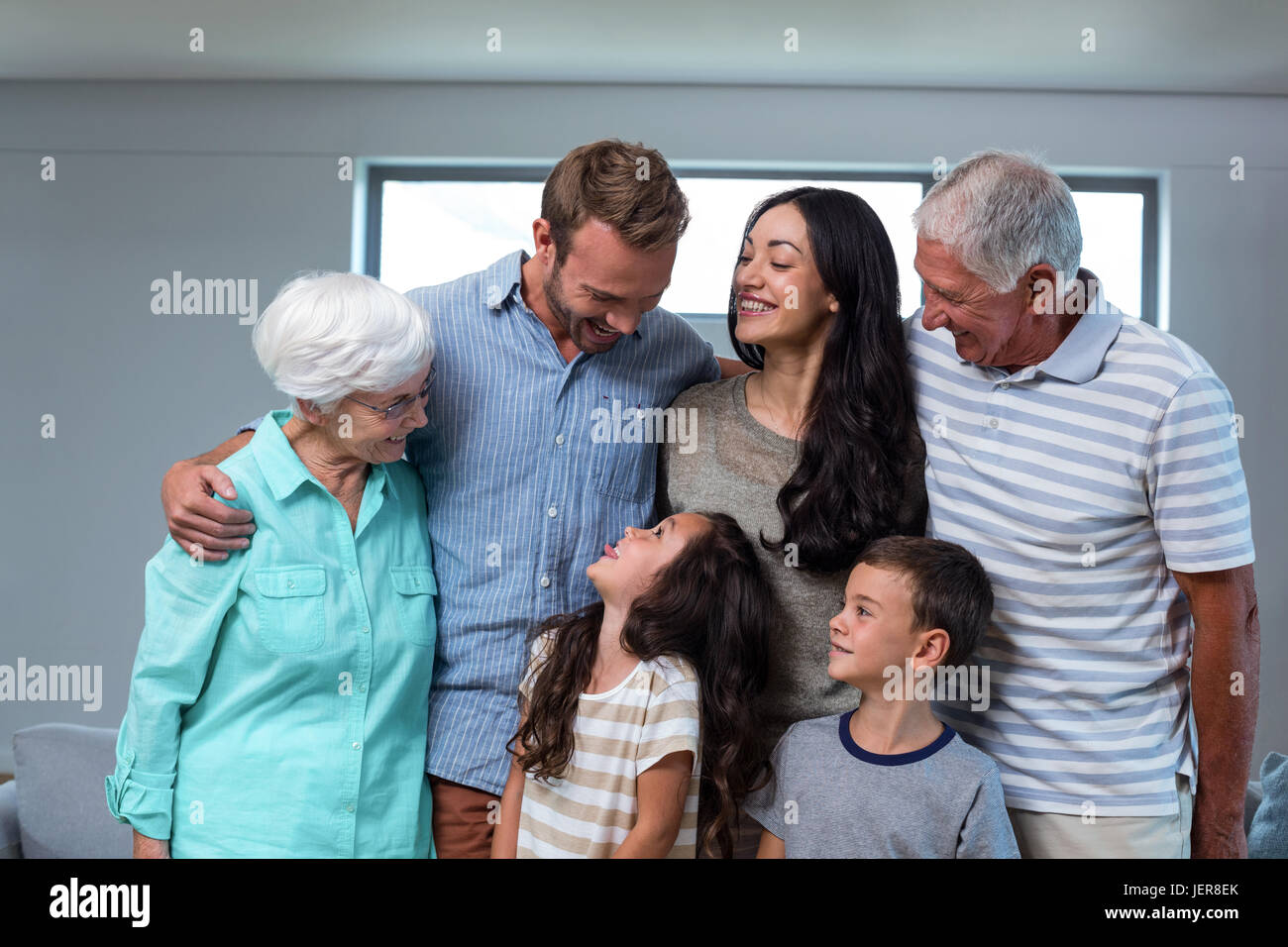 Happy family standing together and smiling Stock Photo - Alamy