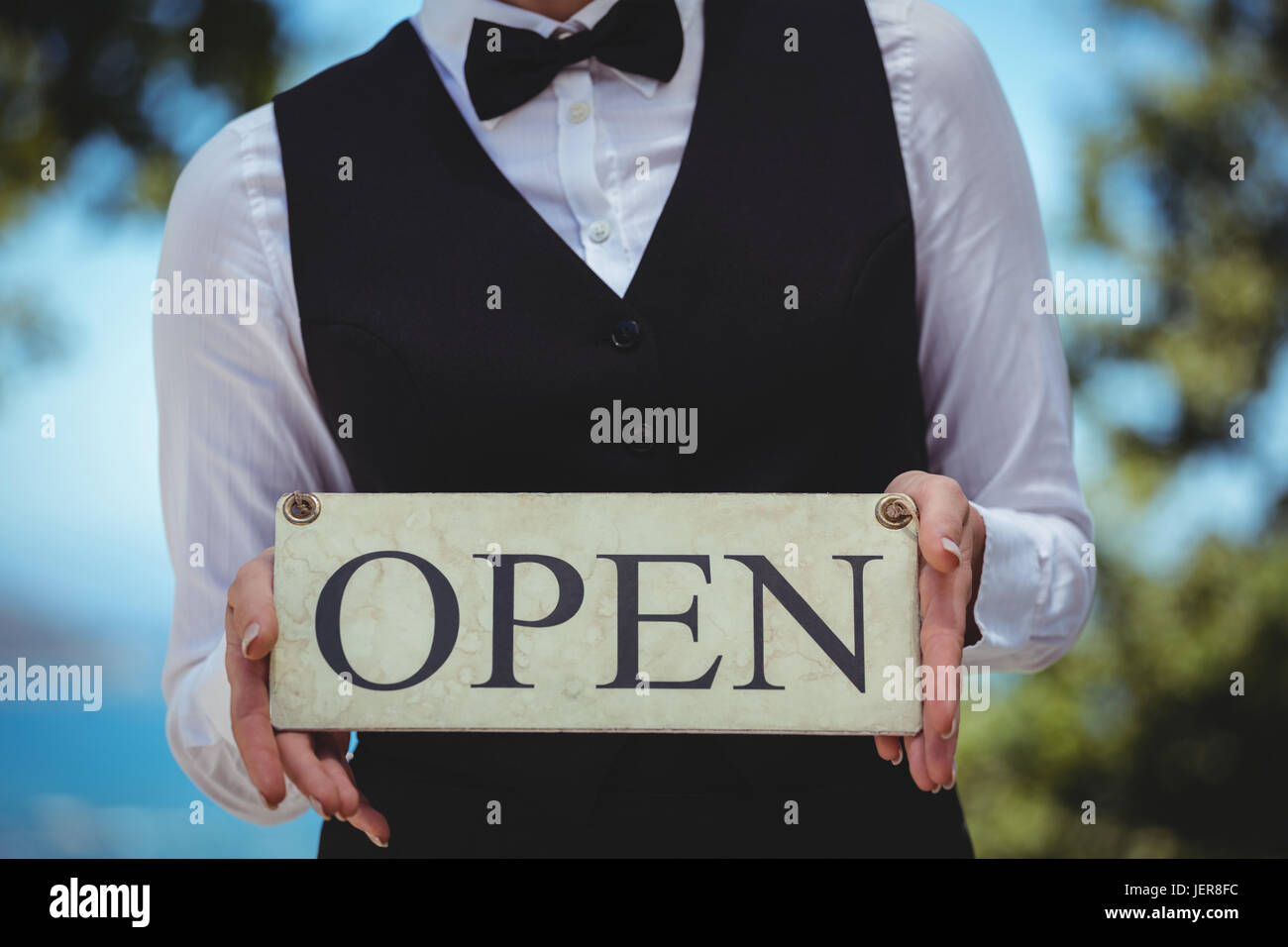 Waitress holding open sign Stock Photo - Alamy
