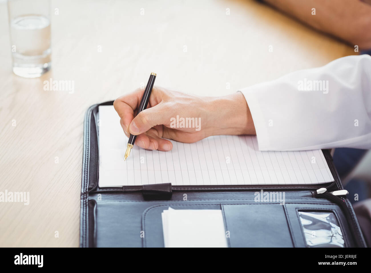 Male doctors hand writing on file Stock Photo - Alamy