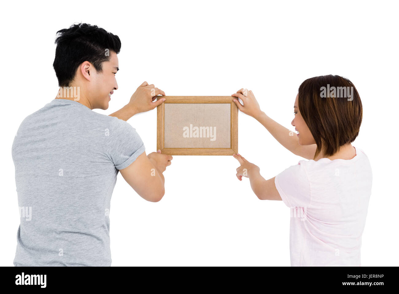 Young couple putting up picture frame Stock Photo - Alamy