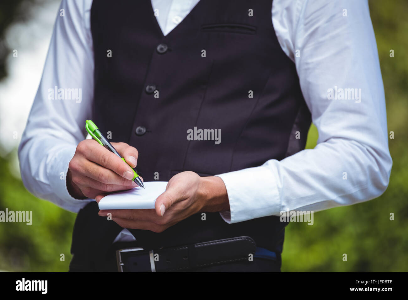 Handsome waiter writing the order Stock Photo - Alamy