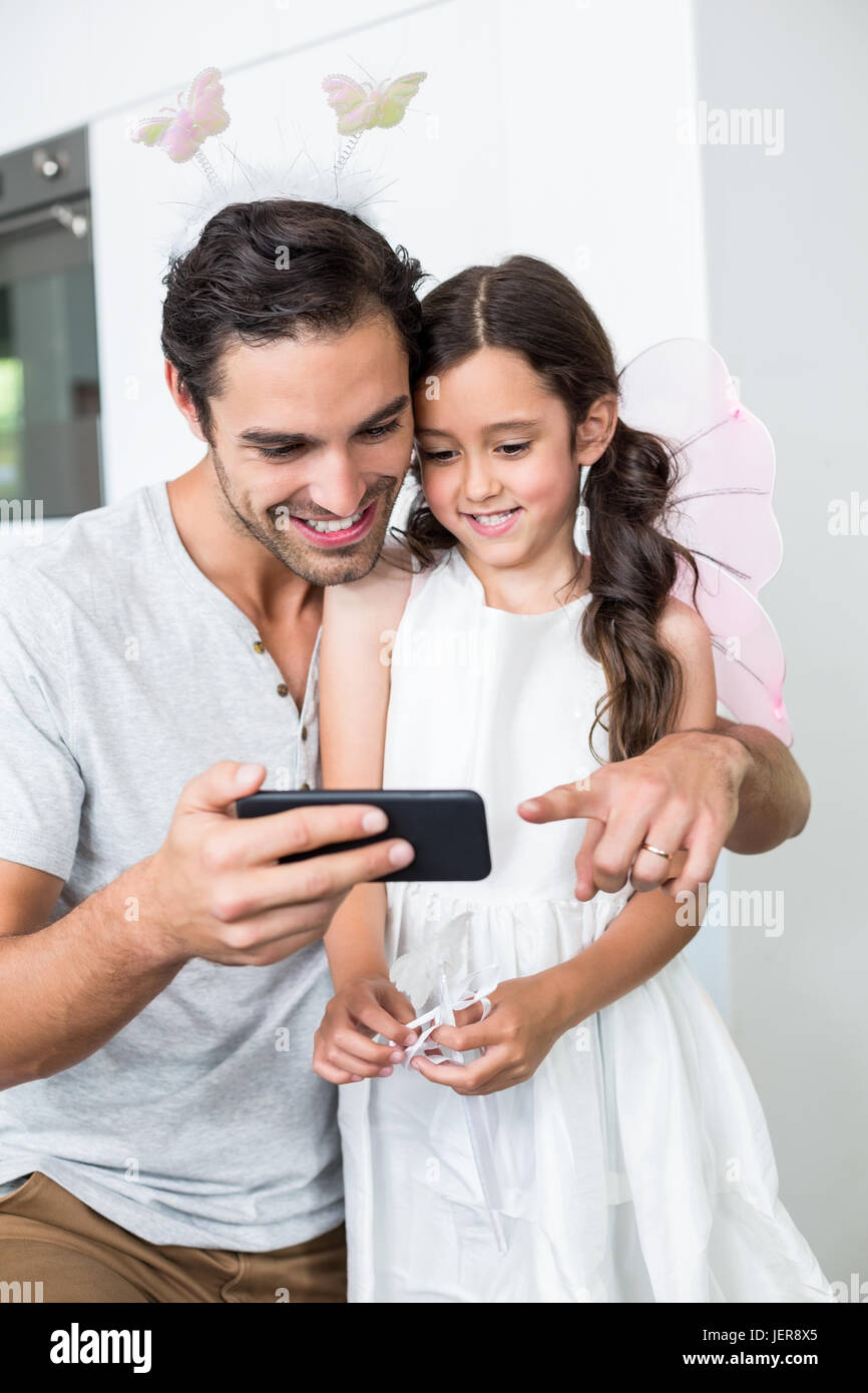 Smiling father using smartphone with daughter Stock Photo - Alamy