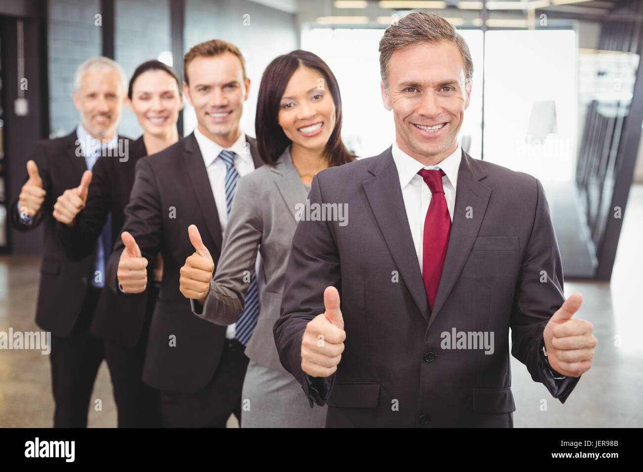 Businesspeople giving thumbs up Stock Photo - Alamy