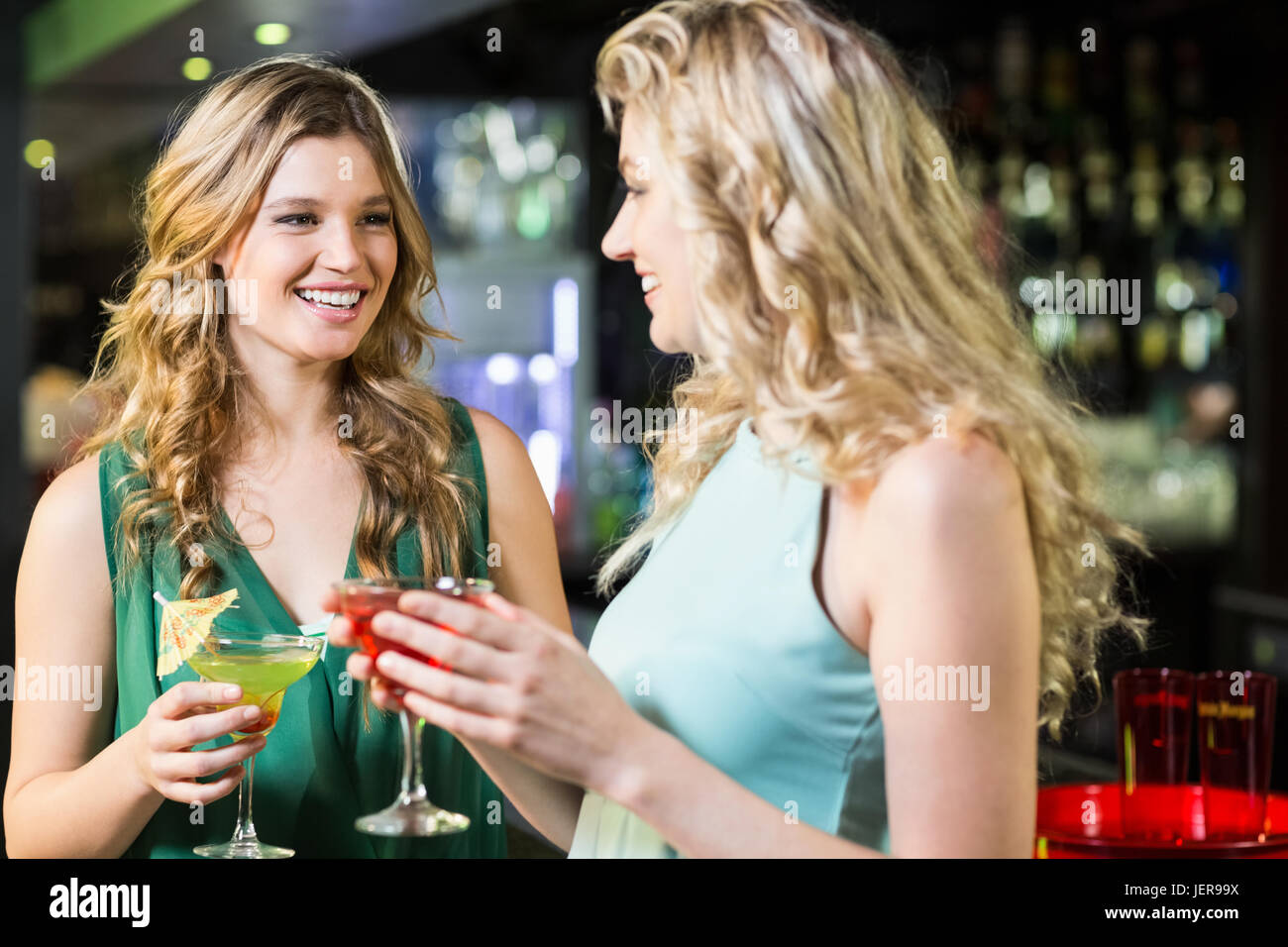 Smiling friends drinking cocktails Stock Photo - Alamy