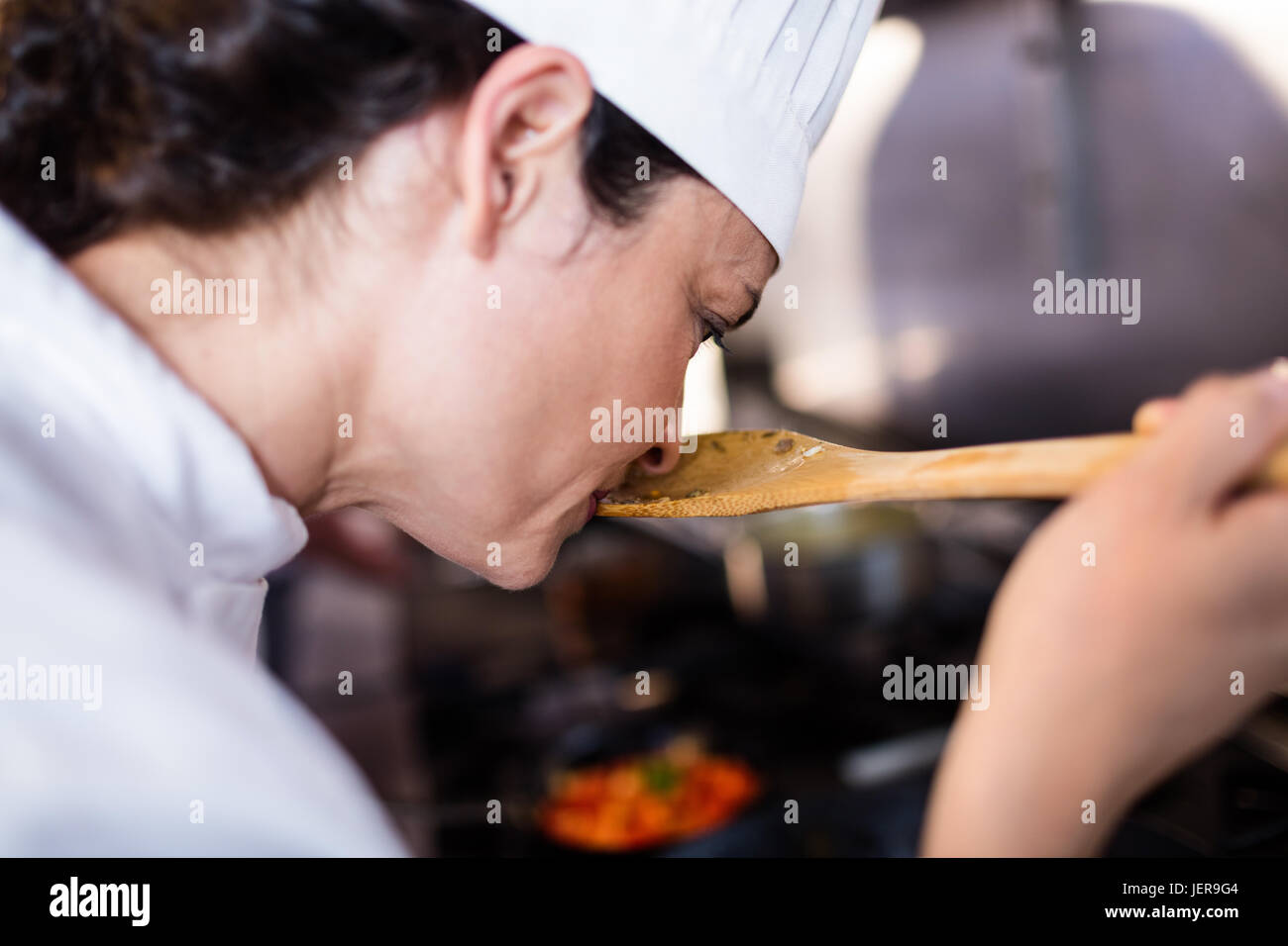 Chef smelling food in the kitchen Stock Photo - Alamy