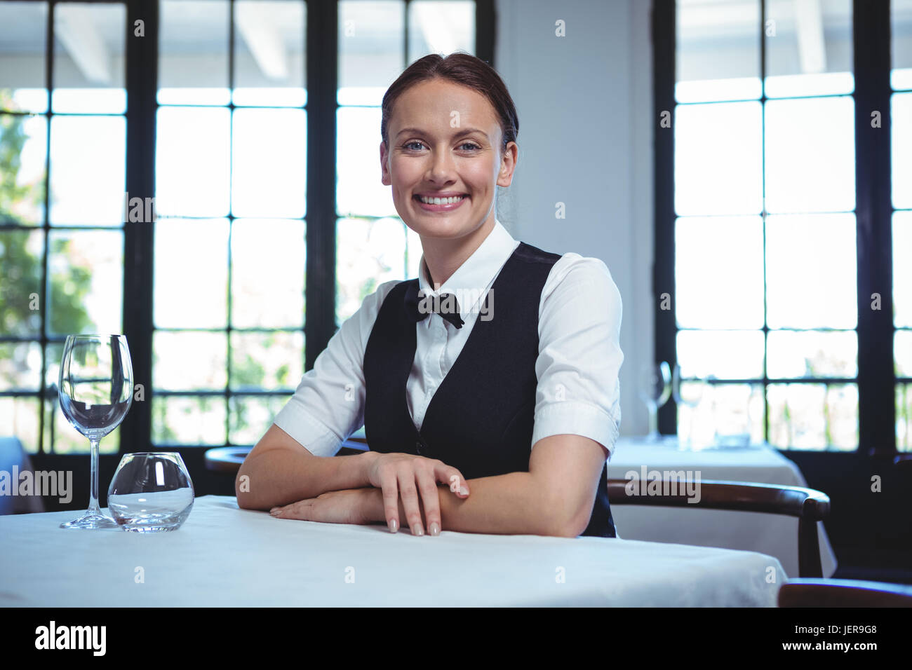 Smiling waitress setting table hi-res stock photography and images - Alamy