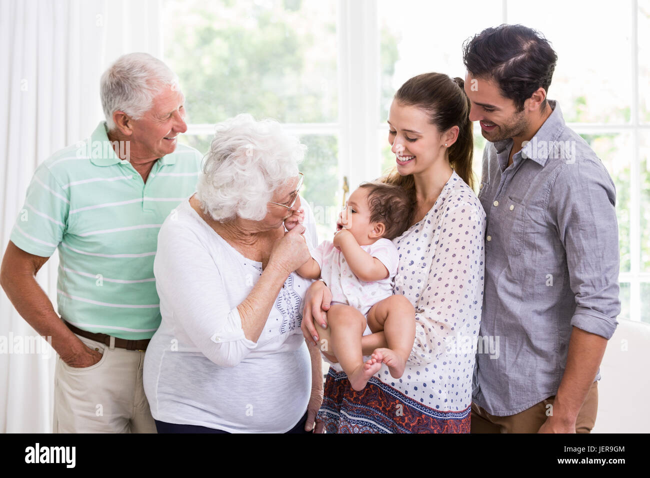 Smiling family playing with baby Stock Photo - Alamy