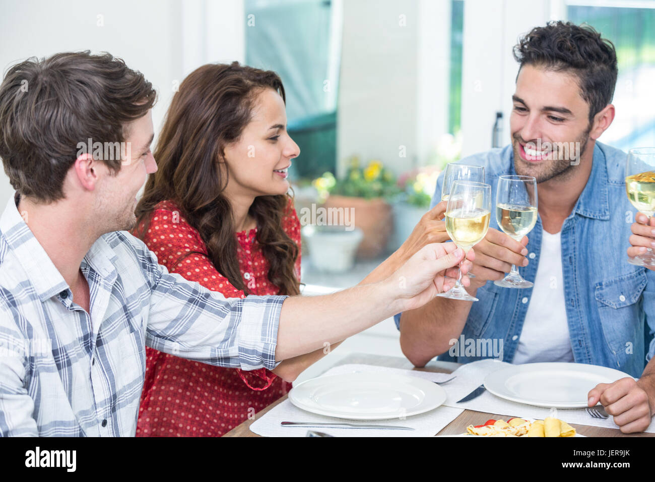 Happy friends toasting white wine Stock Photo - Alamy