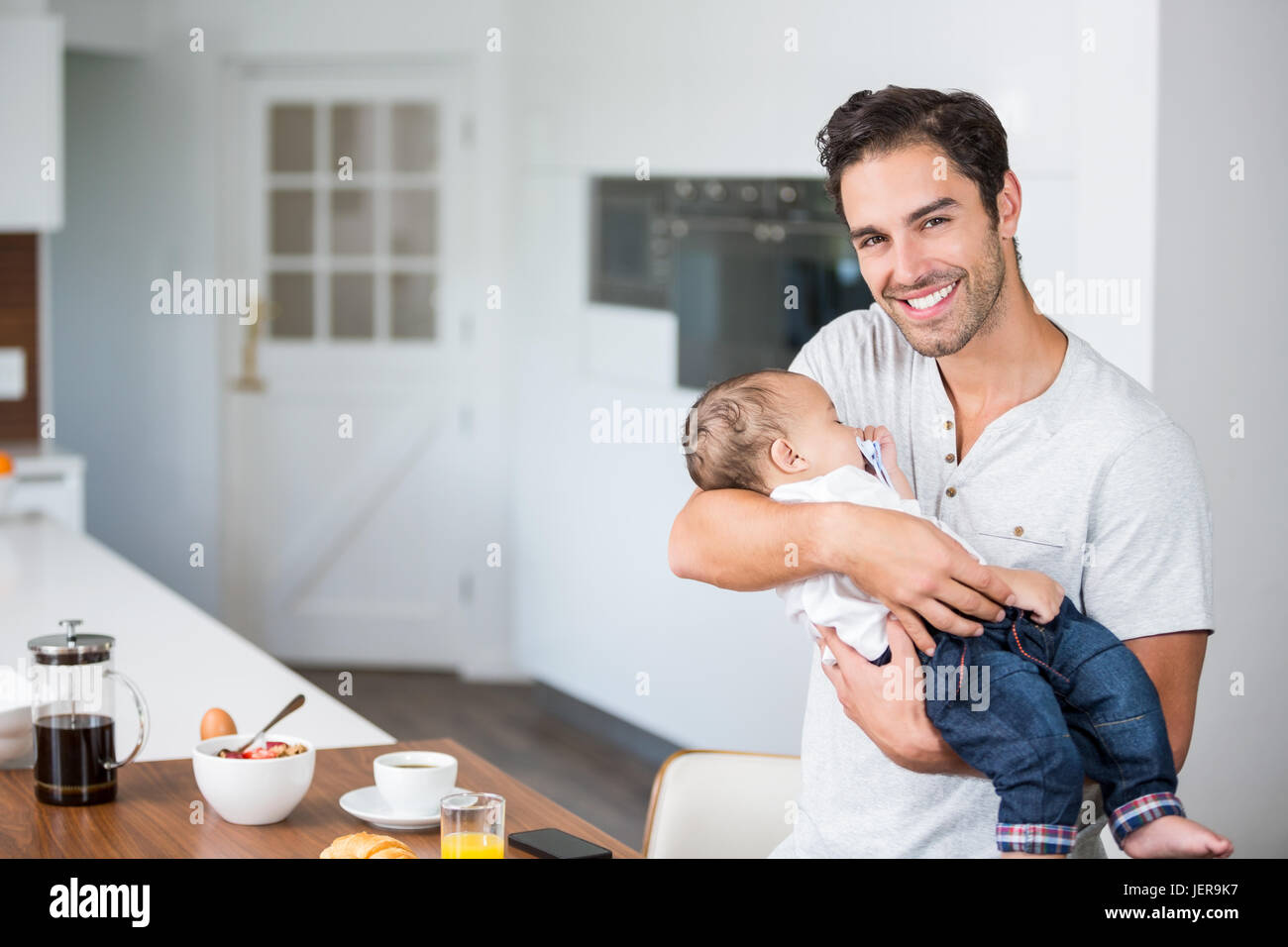 Portrait of happy father carrying baby Stock Photo - Alamy