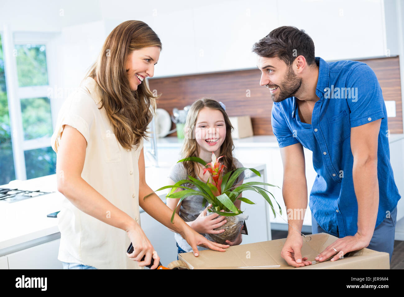 Smiling family packing box Stock Photo - Alamy