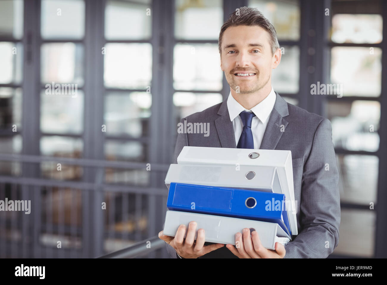 Businessman carrying files stack in office Stock Photo - Alamy